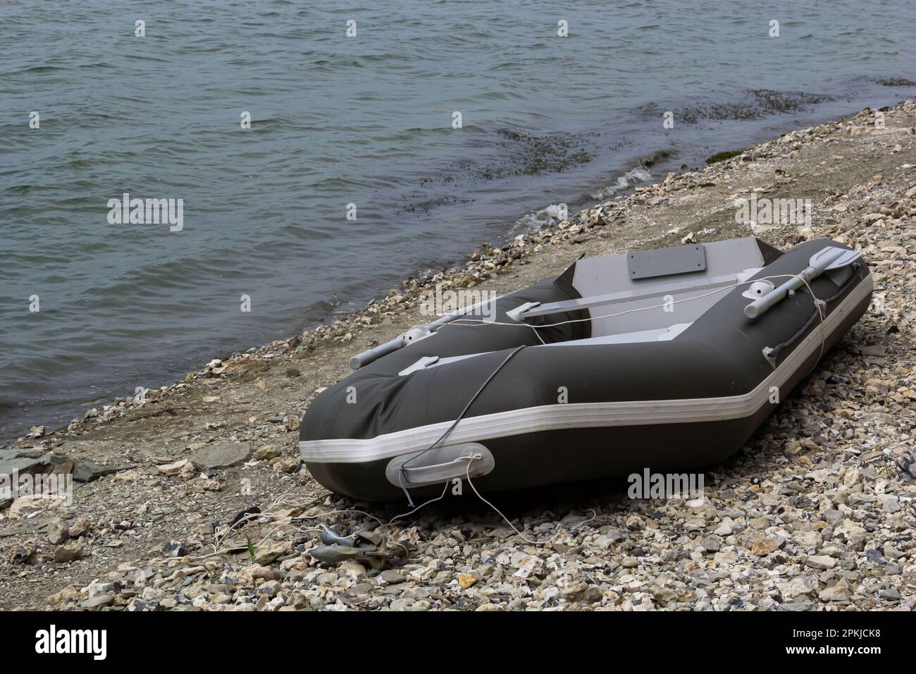 A rubber boat stands on the bank of the river.A means of transportation ...