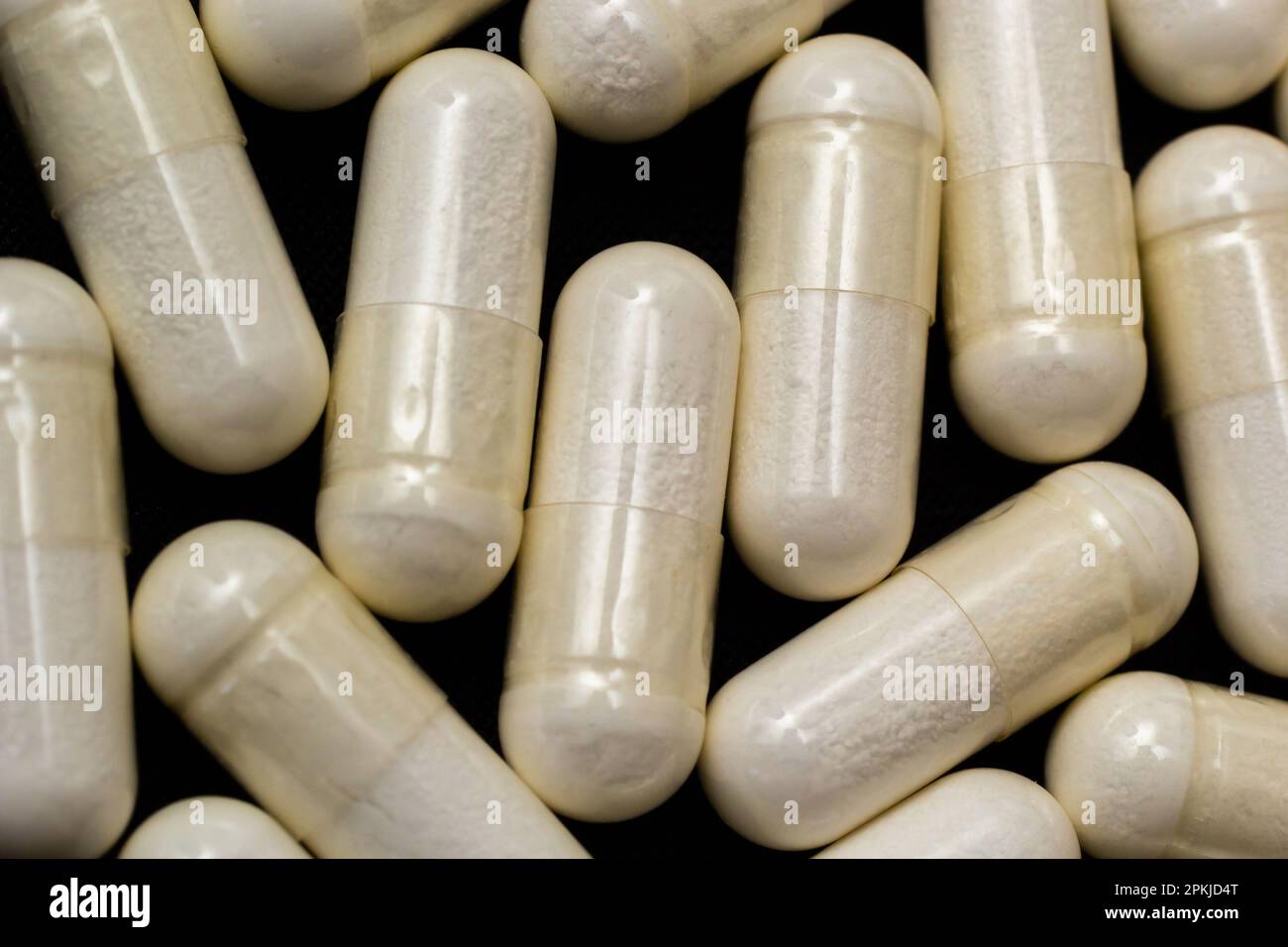 White capsules, pills on a black background. Medicine, healthcare ...