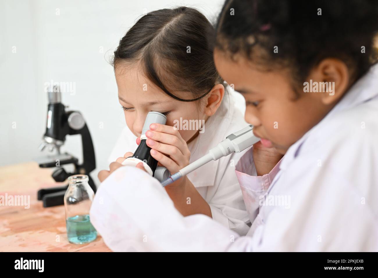 Kids with science lab coat studying and learning in science at school ...