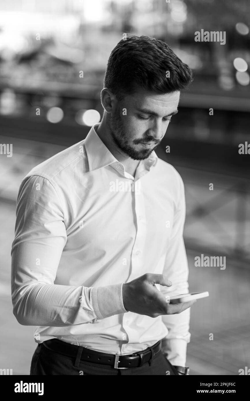 Man watching his Phone with white shirt Stock Photo - Alamy