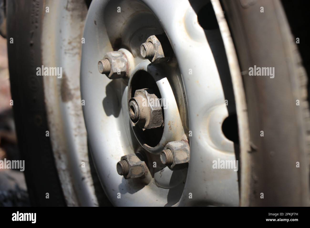 Old rubber car tire with a view of its nut and bolt connection to the ...