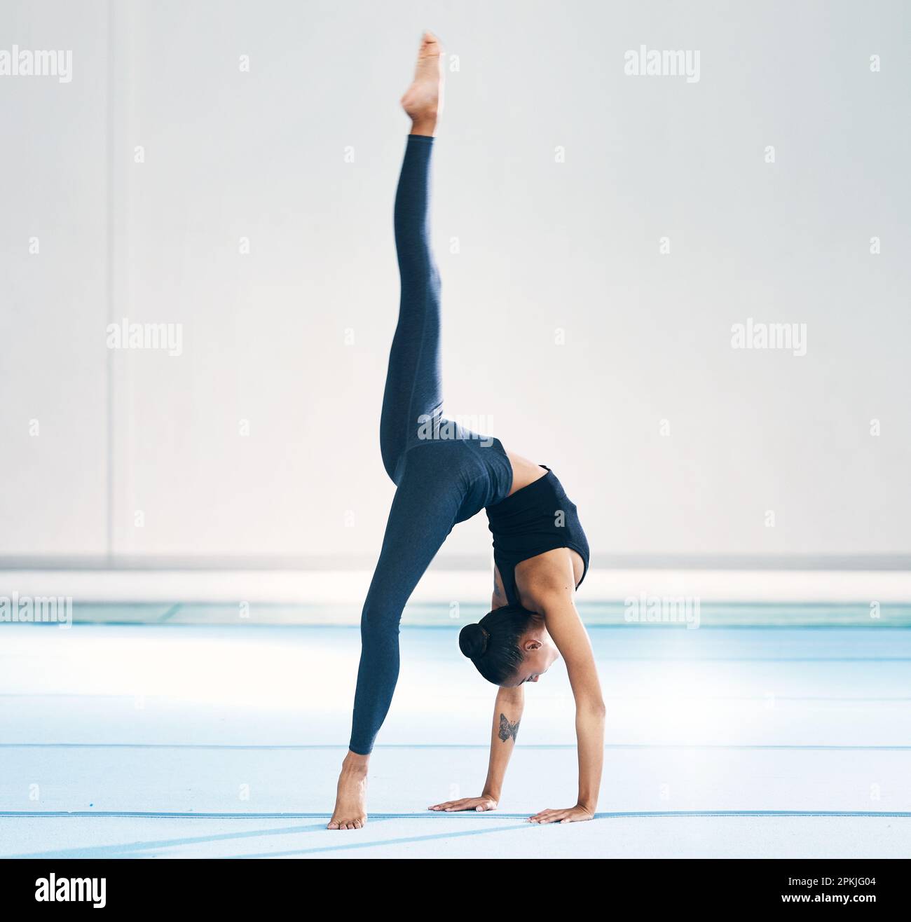 Gymnast, woman and cartwheel for training in gym, exercise and ...