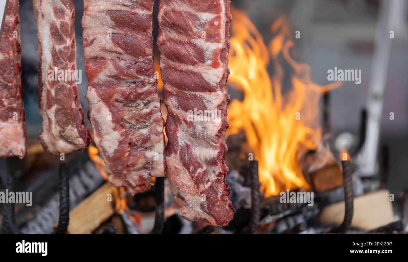 tasty rack of pork ribs cooking on barbecue fire Stock Photo - Alamy