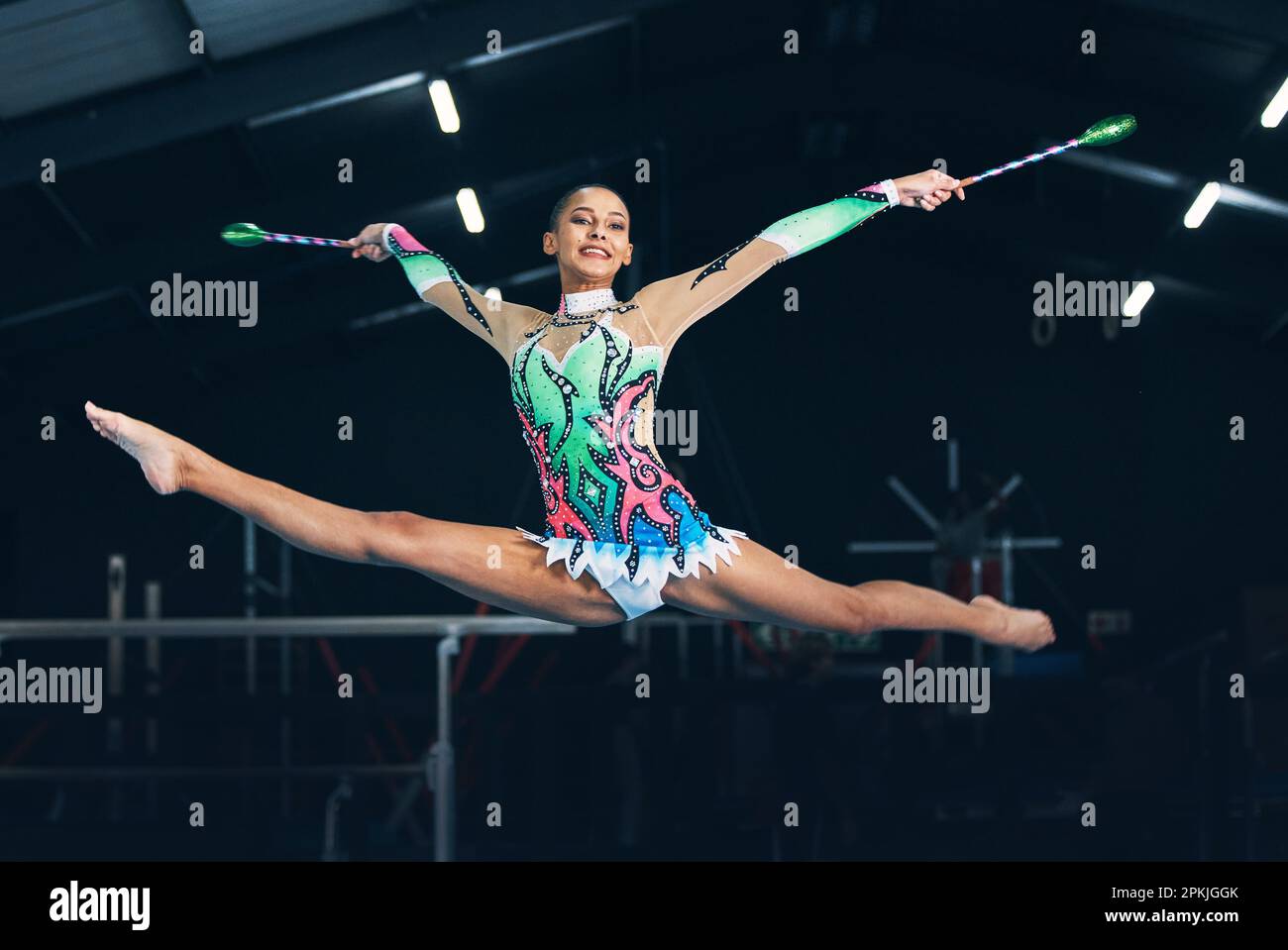 Performance, gymnastics and female jumping with a ribbon in a ...