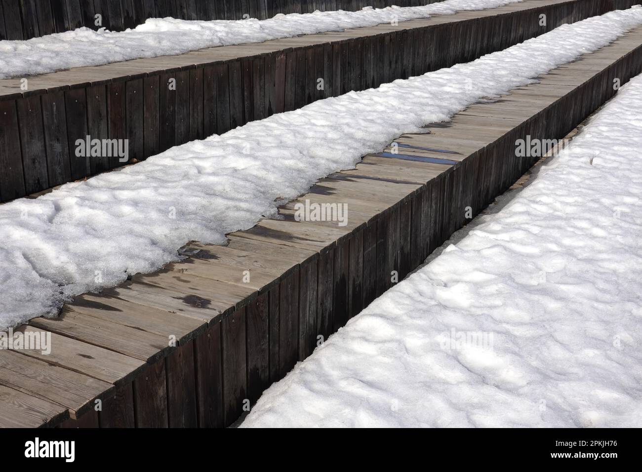Melting on spring snow on the different surfaces of old brown wooden ...