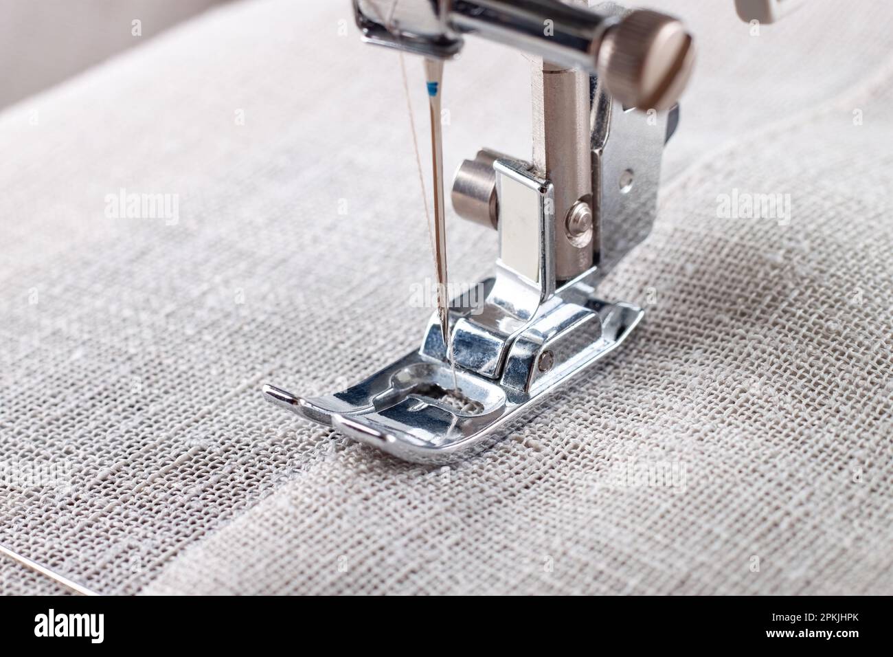 Modern sewing machine presser foot with linen fabric and thread ...