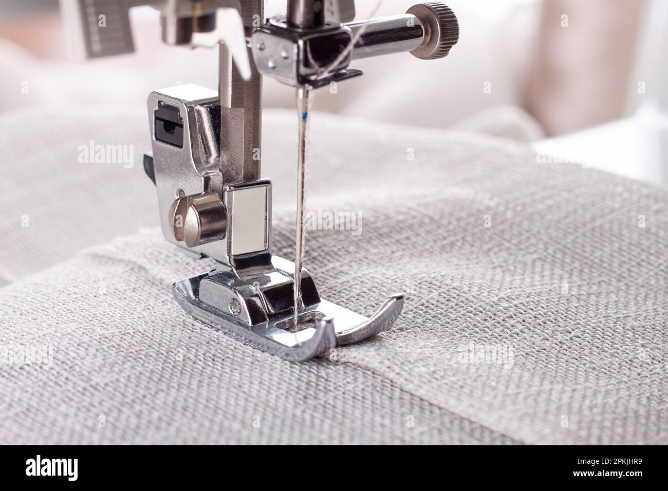 Modern sewing machine presser foot with linen fabric and thread ...