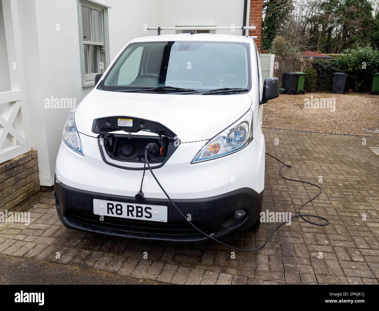 An electric van being charged on a private drive Stock Photo - Alamy