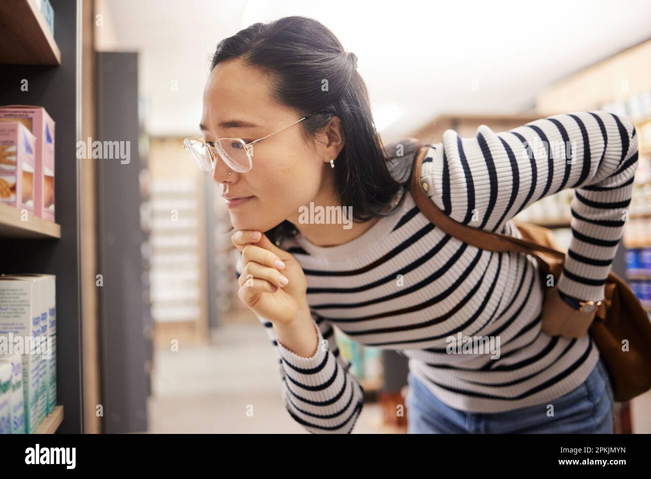 Thinking, woman and choice of shopping at shelf, retail products and ...