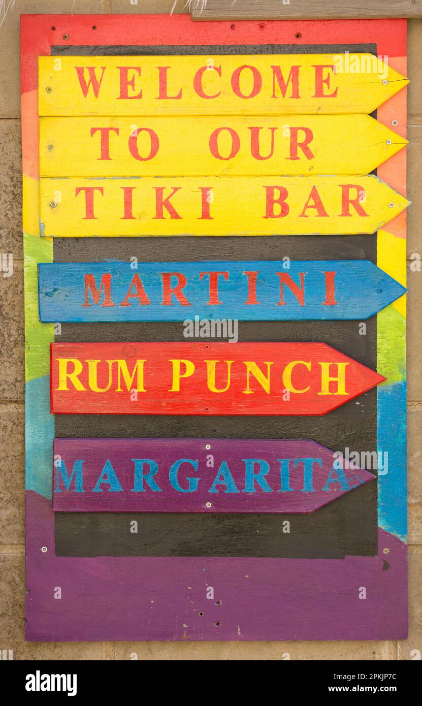 Colourful signs outside the Tiki Bar in West Bay Dorset indicating ...