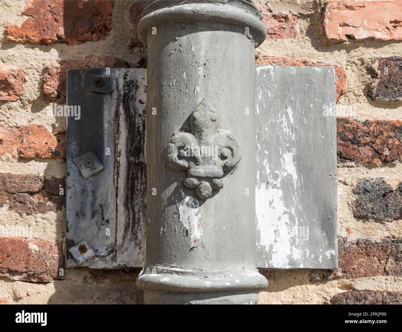 A fleur-de-lys motif or symbol on a rainwater pipe on the Tudor house ...