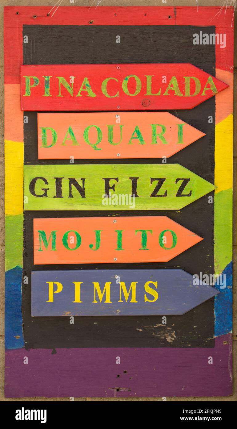 Colourful signs outside the Tiki Bar in West Bay Dorset indicating ...