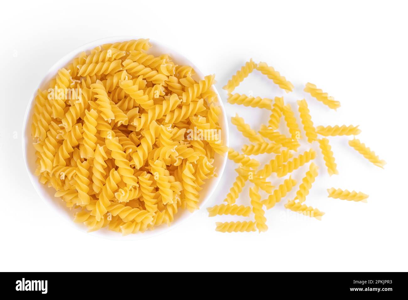 Fusilli in bowl and isolated on white background. Raw pasta spiral ...