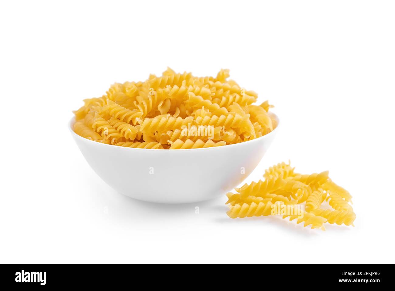 Fusilli in bowl and isolated on white background. Raw pasta spiral ...