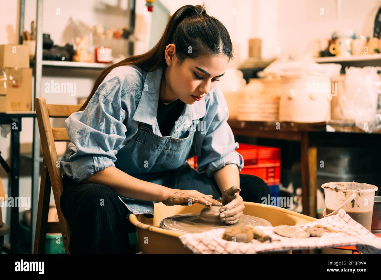 Potter making jug of clay on potter wheel circle in workshop Stock Photo - Alamy