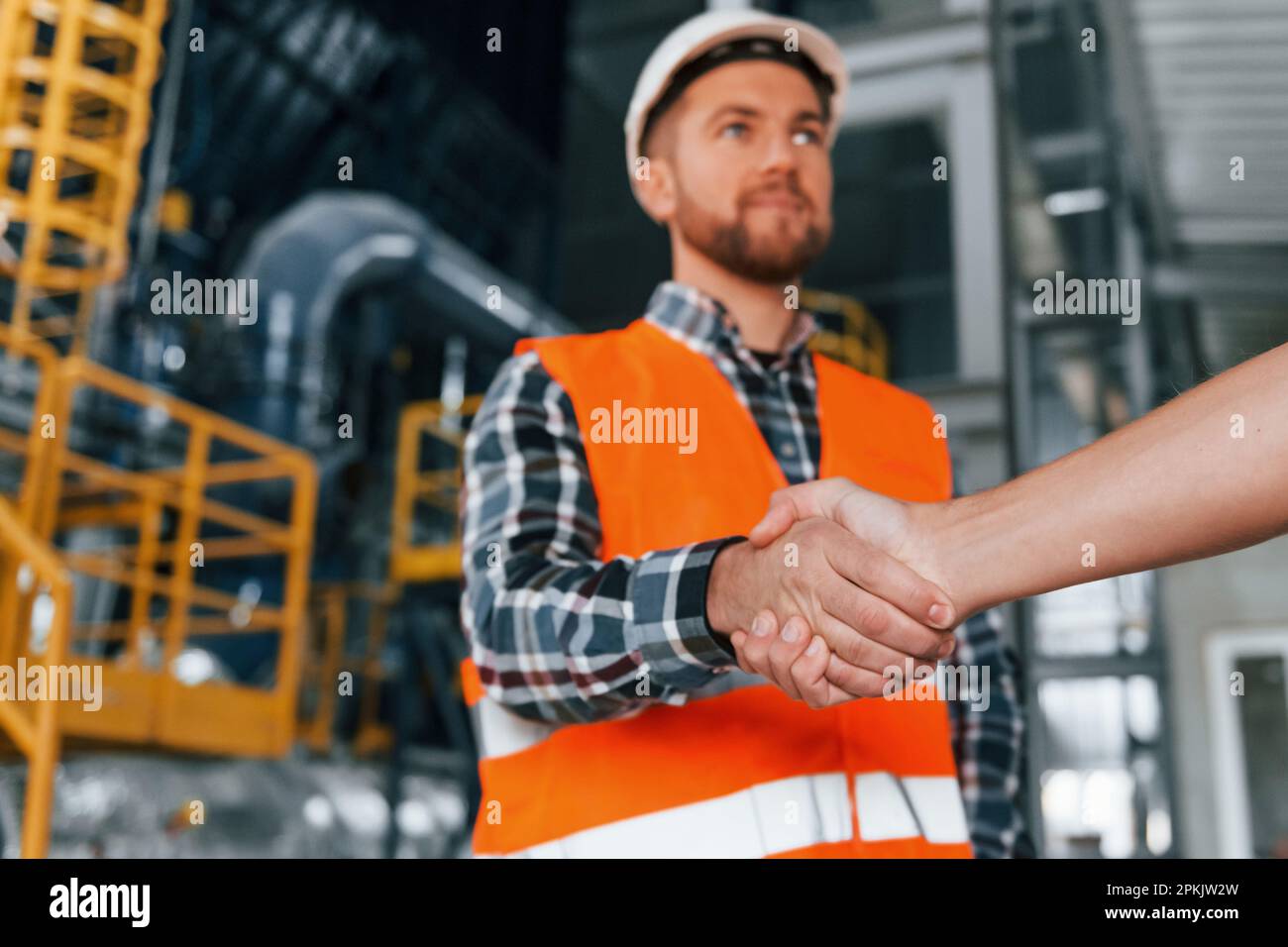 Making handshake with customer. Construction worker in uniform is in ...