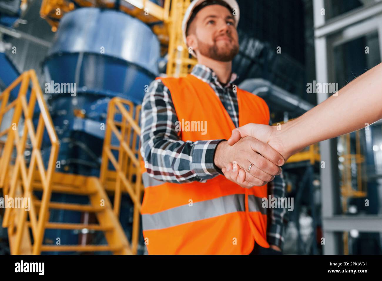 Making handshake with customer. Construction worker in uniform is in ...