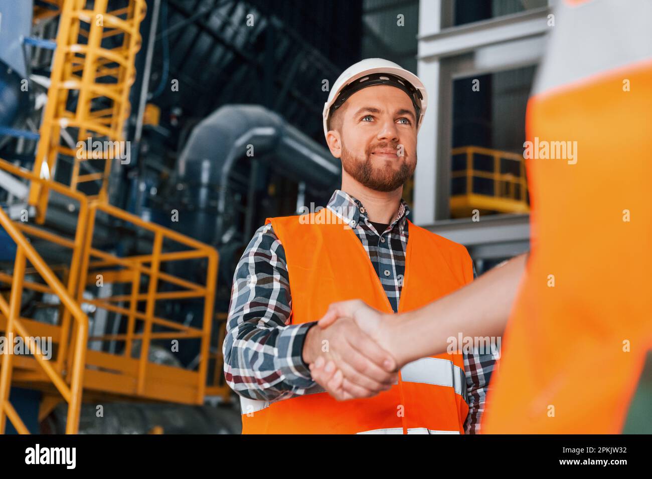 Making handshake with customer. Construction worker in uniform is in ...