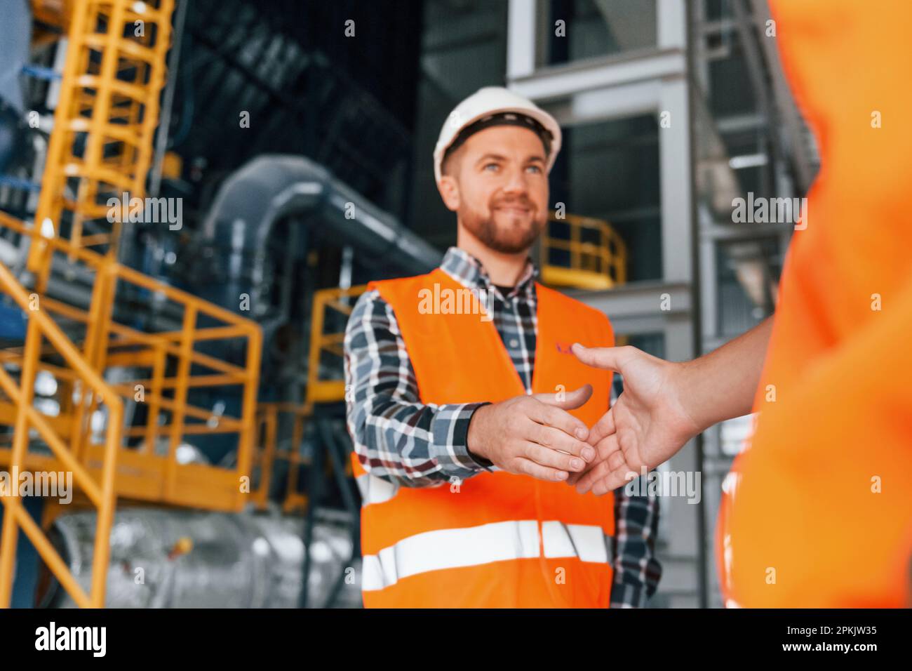 Making handshake with customer. Construction worker in uniform is in ...