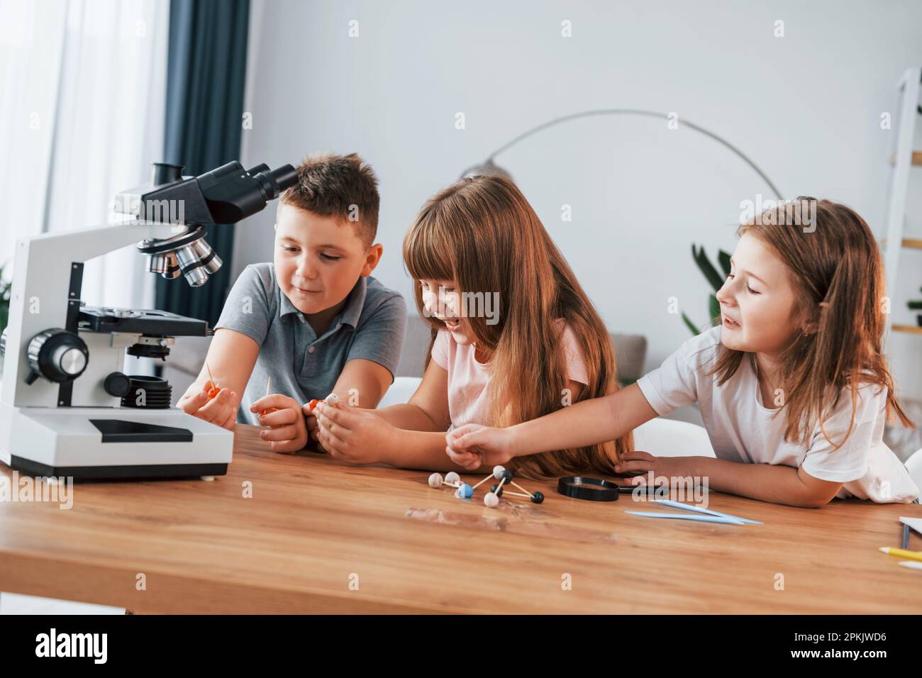 Using microscope. Kids having fun in the domestic room at daytime ...