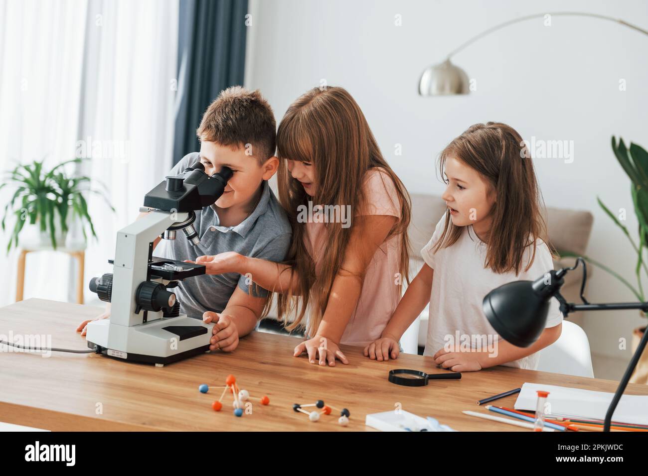 Using microscope. Kids having fun in the domestic room at daytime ...