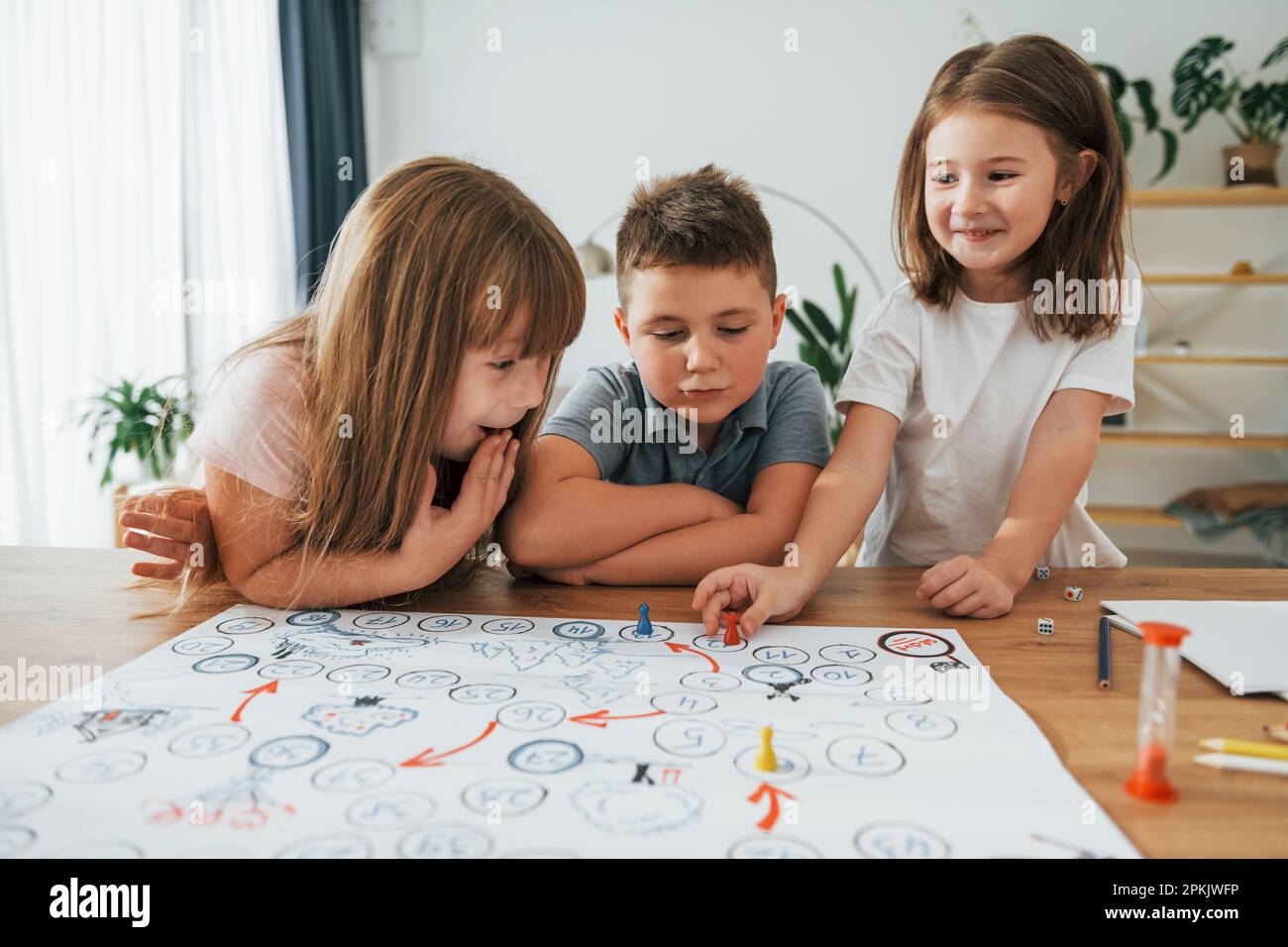 Playing game together. Kids having fun in the domestic room at daytime ...