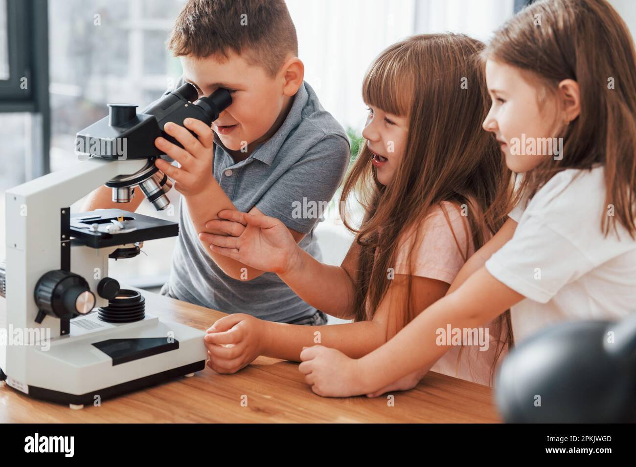 With microscope. Kids having fun in the domestic room at daytime ...