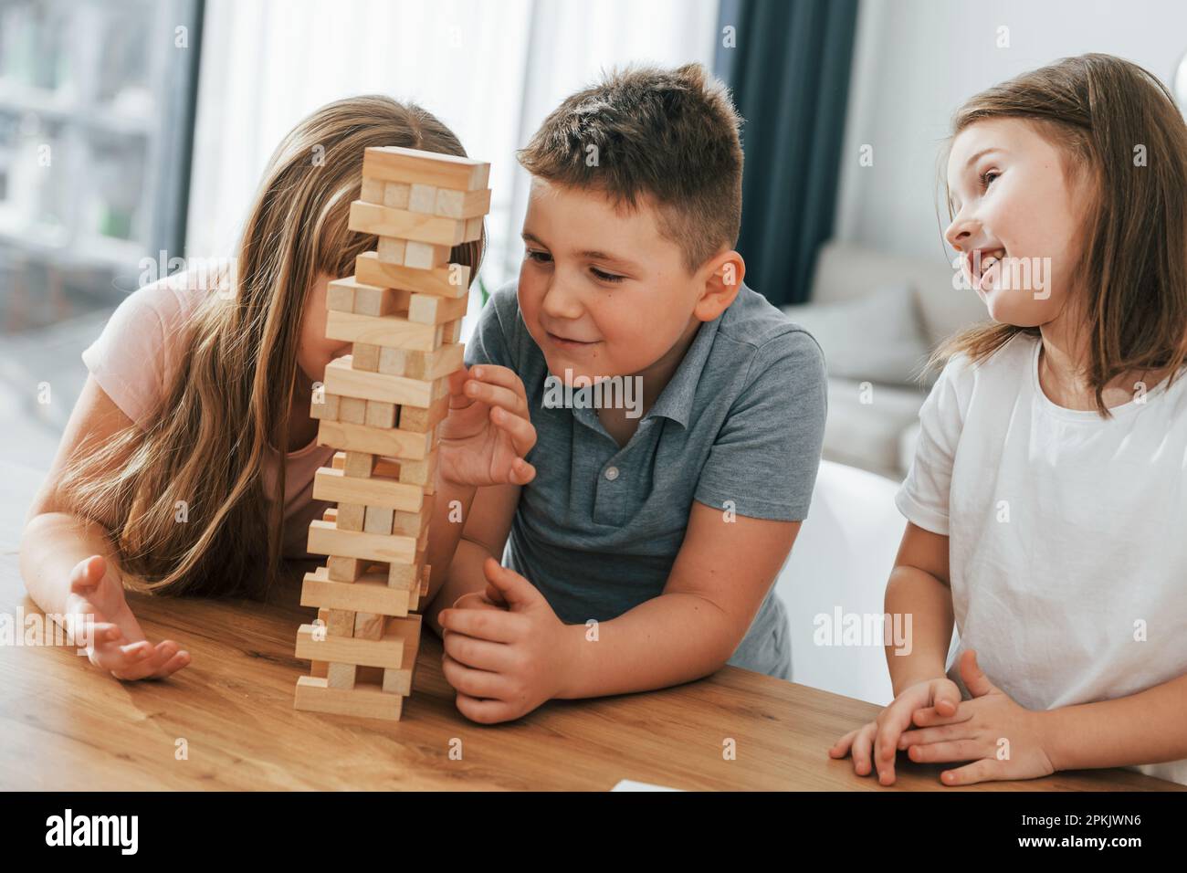 Focused on the jumbling tower game. Kids having fun in the domestic ...
