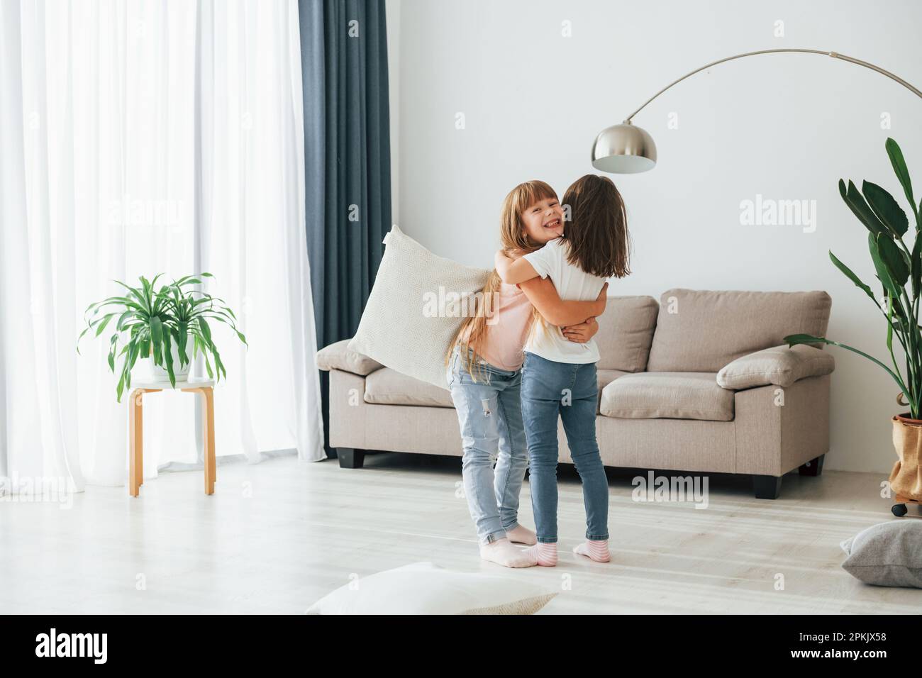 Girls are playing pillow fight game. Kids having fun in the domestic ...