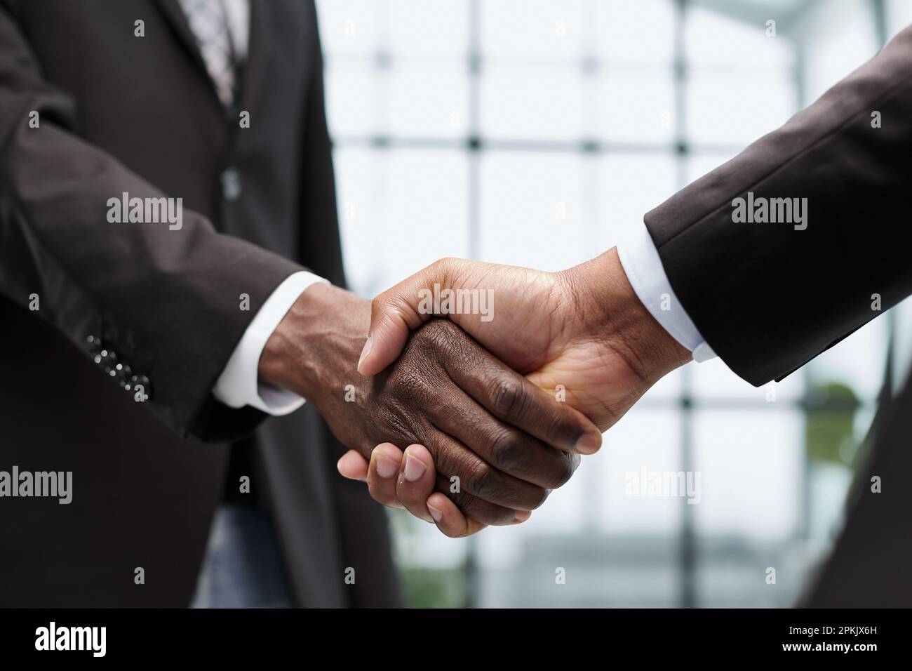 Businessmen reach out to each other to shake hands Stock Photo - Alamy