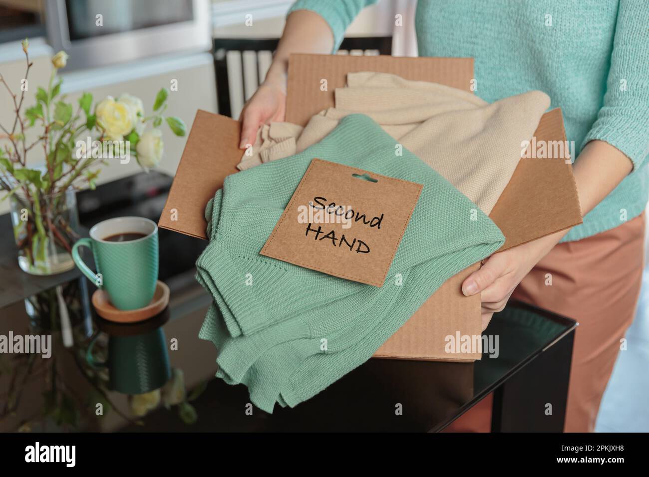 Woman packing box with used clothes for resale Stock Photo - Alamy