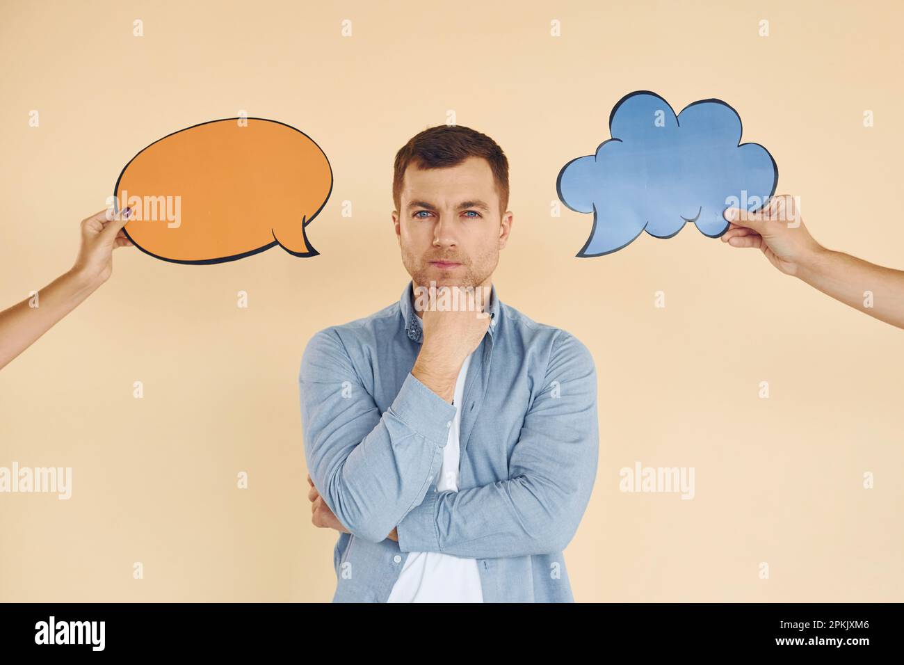 Thinking about two ideas. Man standing in the studio with empty signs ...