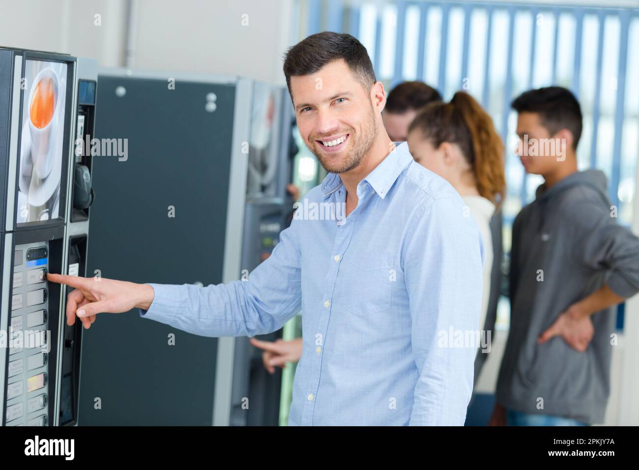 man posing while pressing vending machine Stock Photo - Alamy