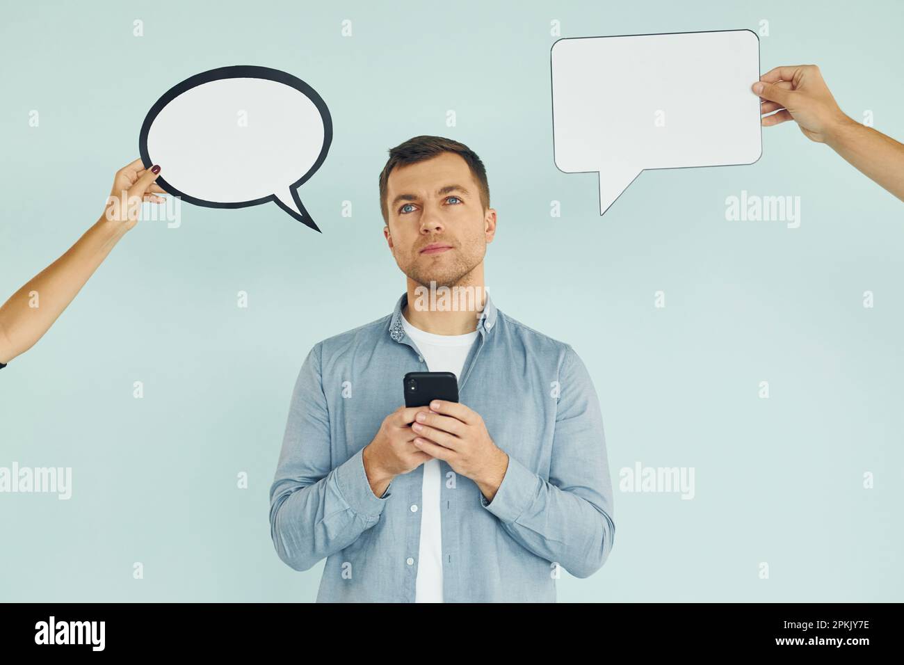 Thinking what to answer. Man standing in the studio with empty signs ...