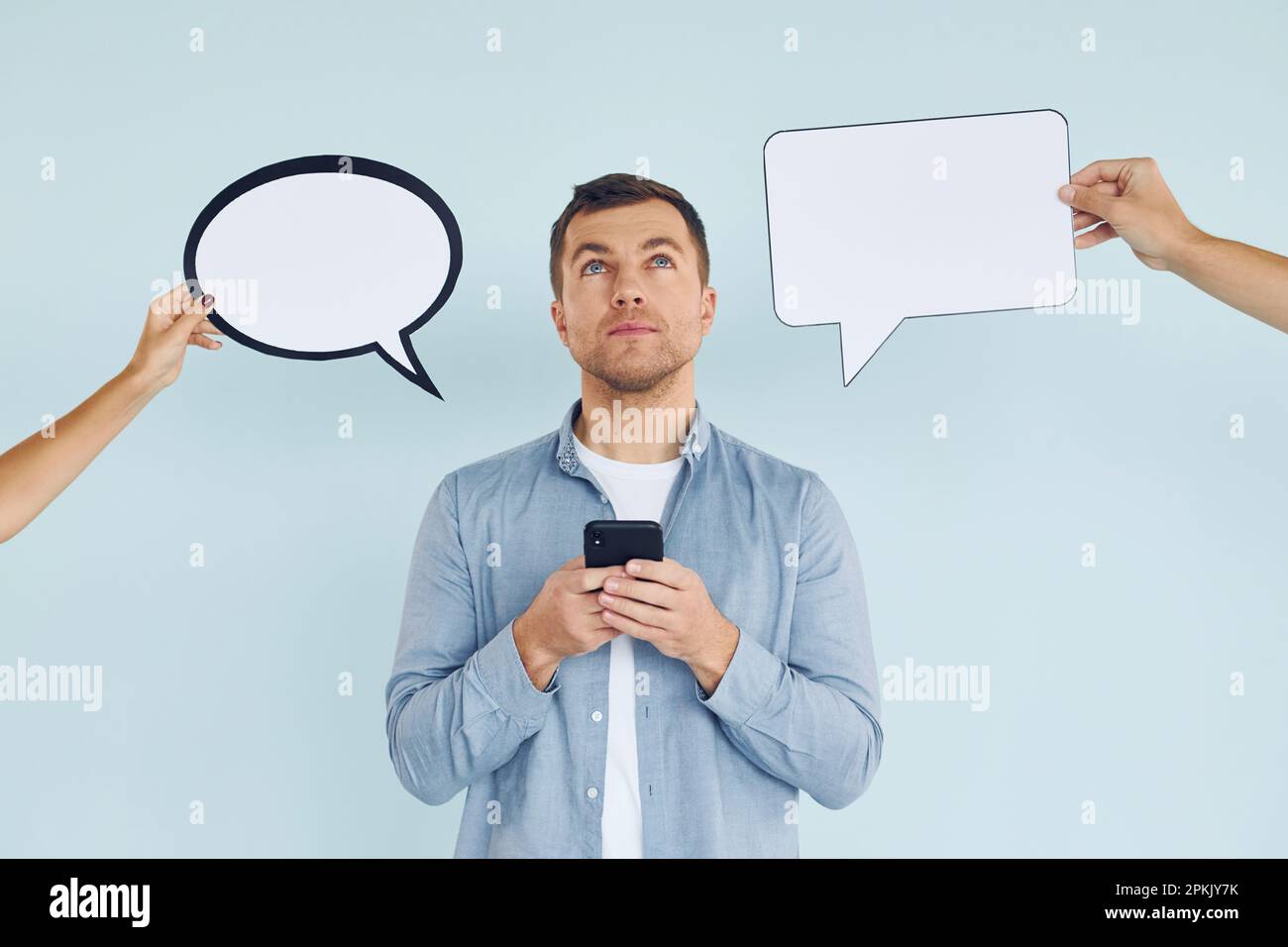 Thinking what to answer. Man standing in the studio with empty signs ...