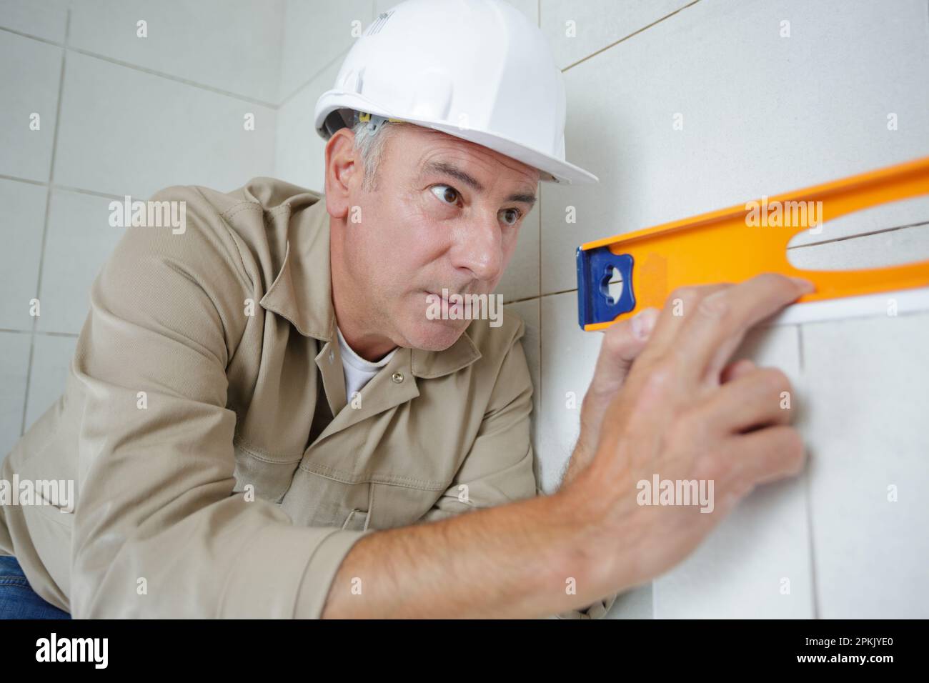mature repairman helping woman to use builder level Stock Photo - Alamy