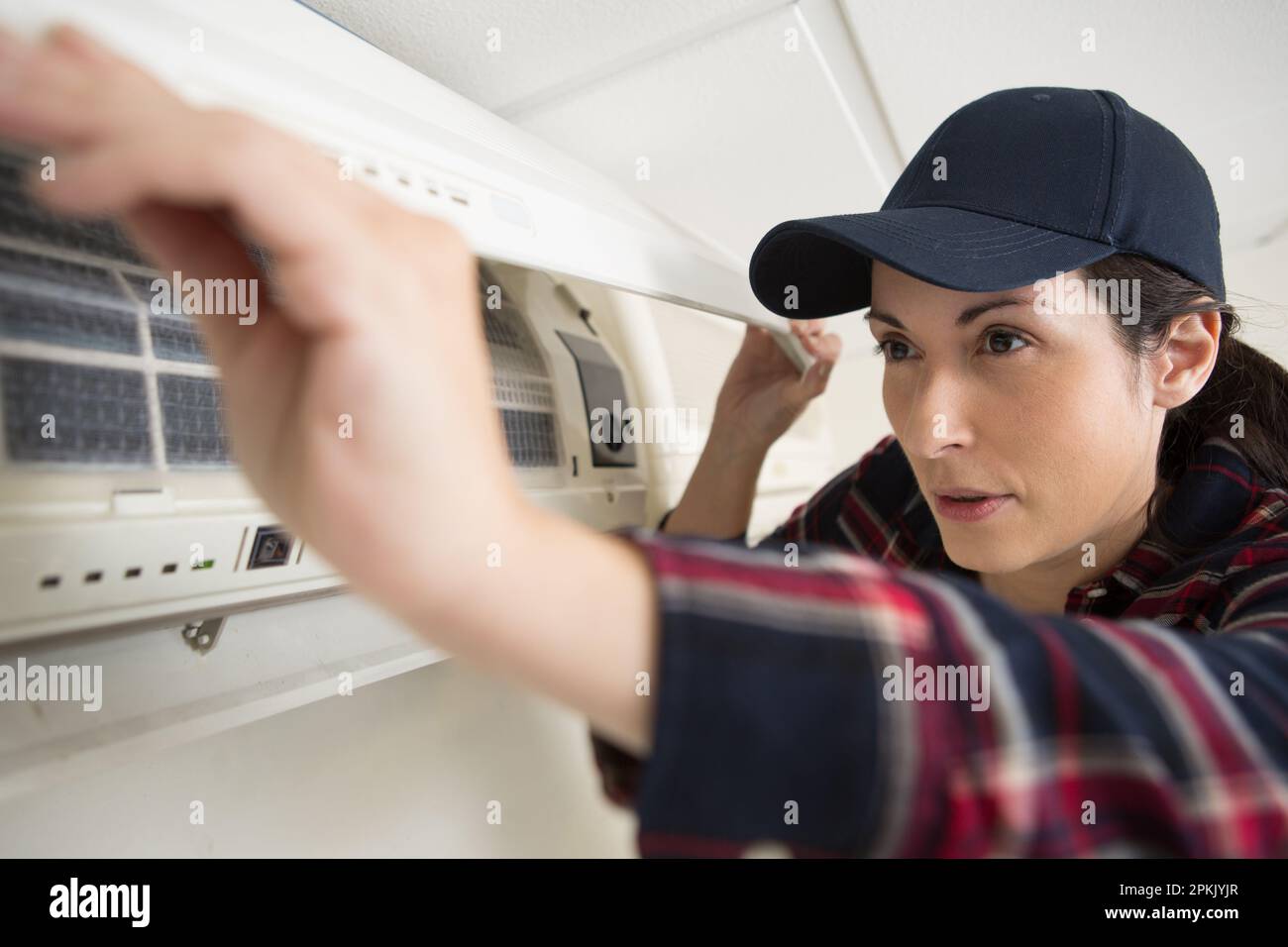 female engineer repairing wall mounted air conditioning unit Stock ...