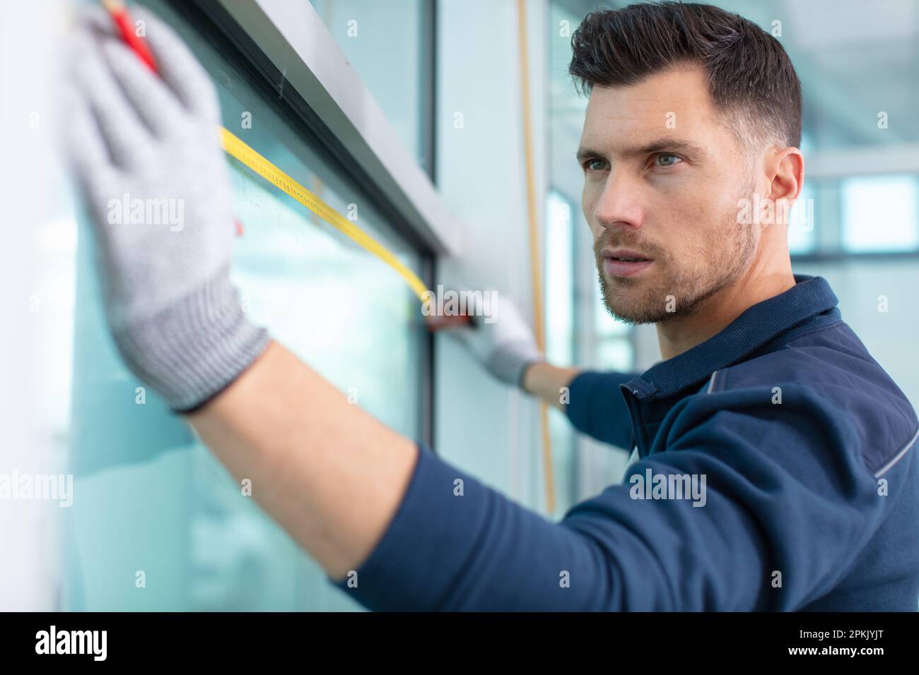 service man measuring window for installation indoors Stock Photo - Alamy