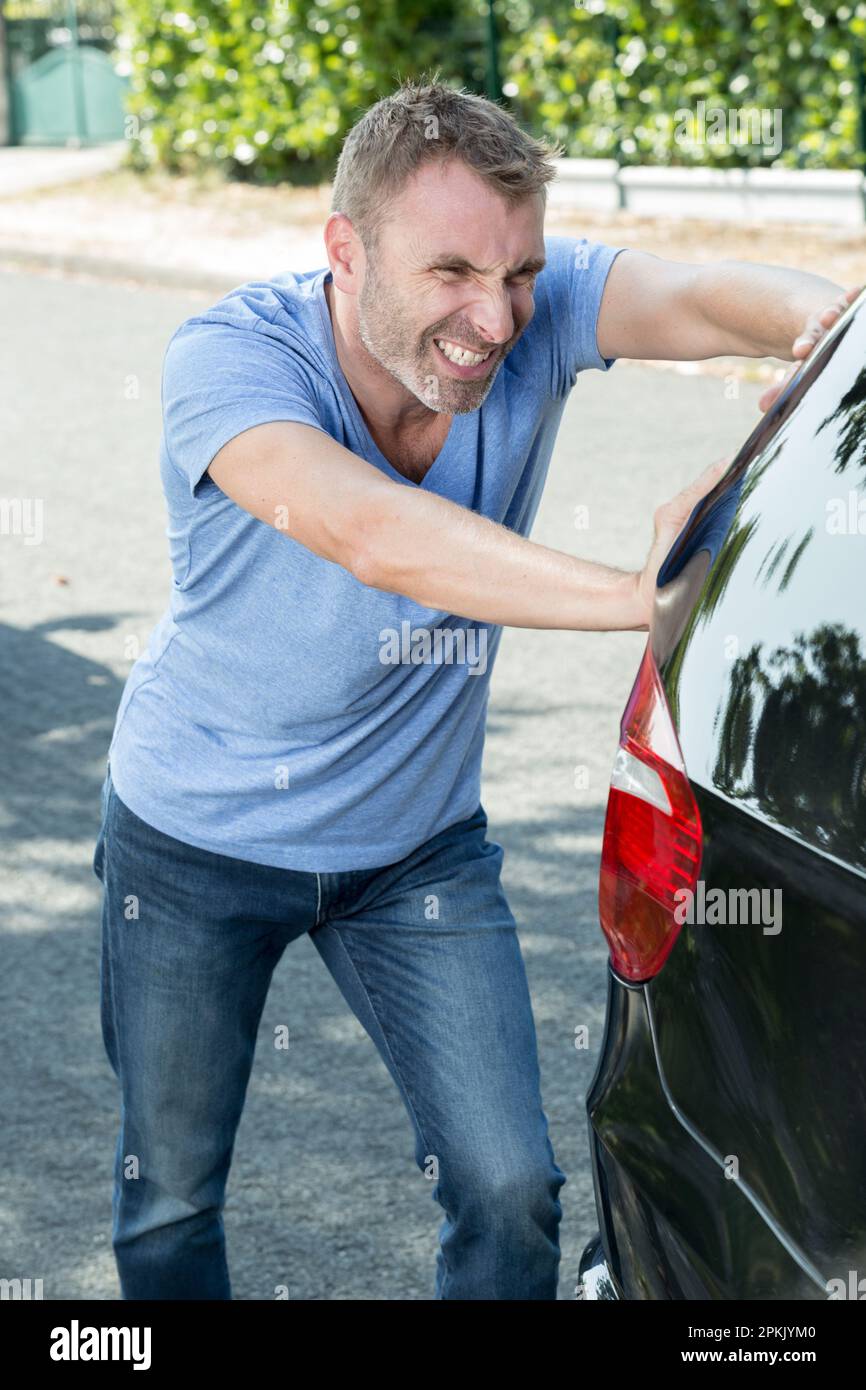 angry man pushing a broken down car Stock Photo - Alamy