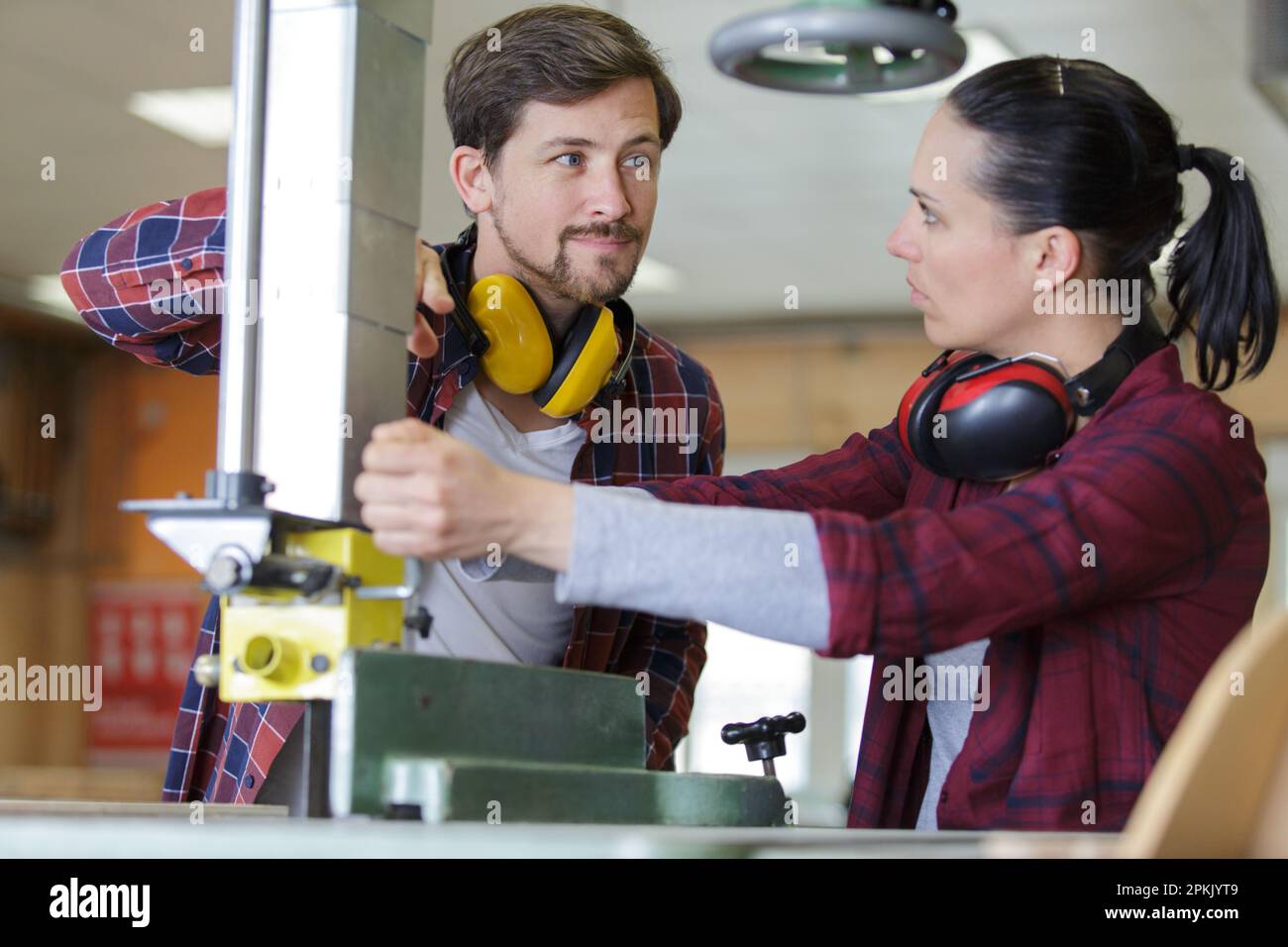 carpenter showing female apprentice how to use a machine Stock Photo ...