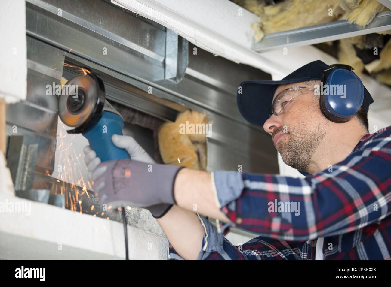 man using an angle grinder on steel window Stock Photo - Alamy