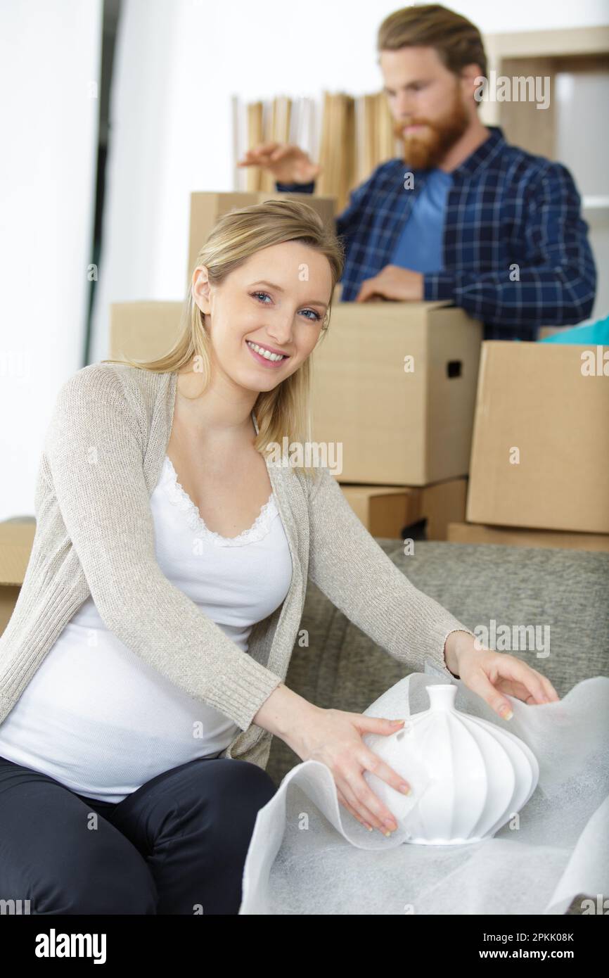 young couple of man and pregnant wife packing in boxes Stock Photo - Alamy