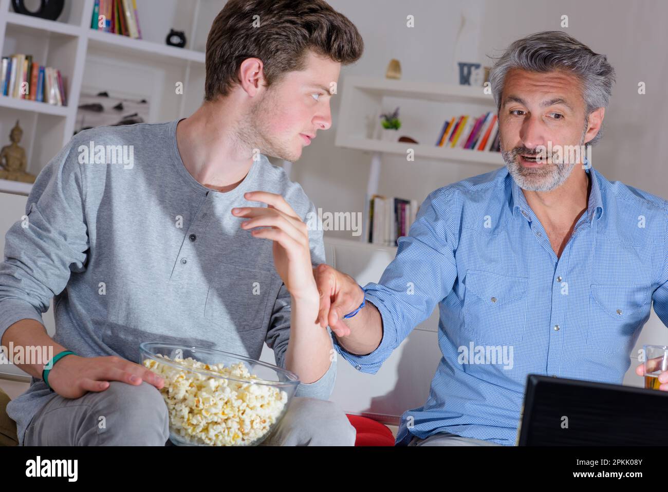 Man having idea while watching television with another man Stock Photo ...