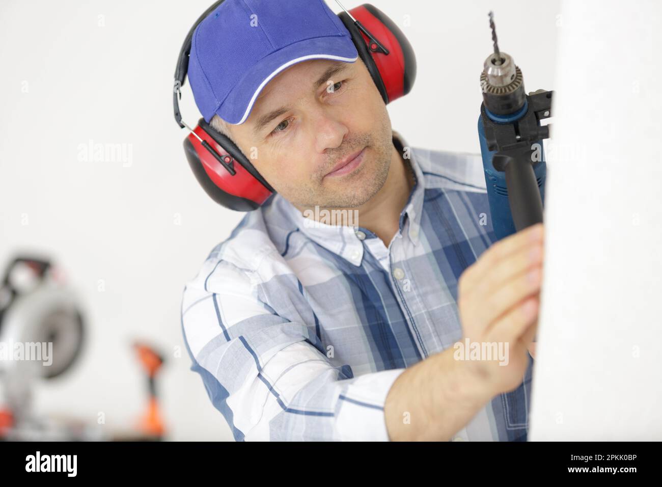 worker with protective soundproofing ear muffs using drill Stock Photo ...