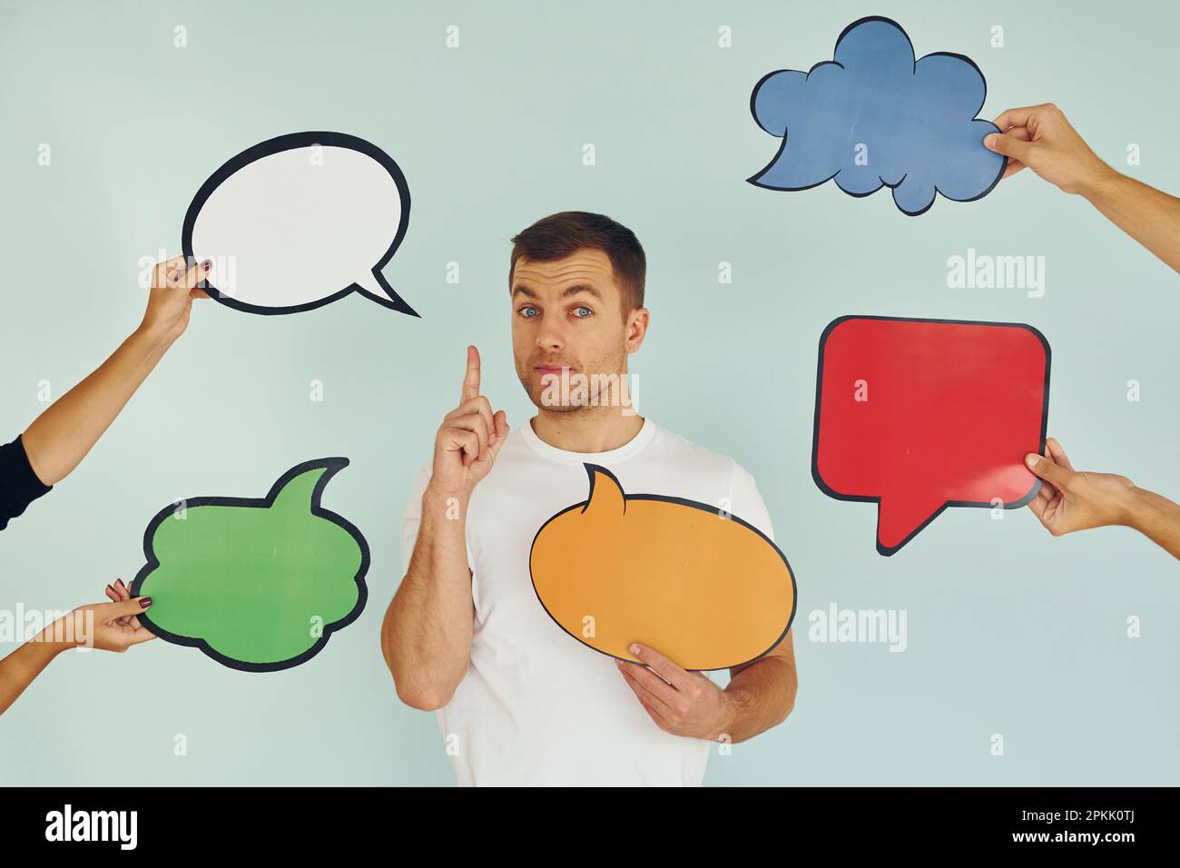 Many hands holding signs. Man standing in the studio Stock Photo - Alamy