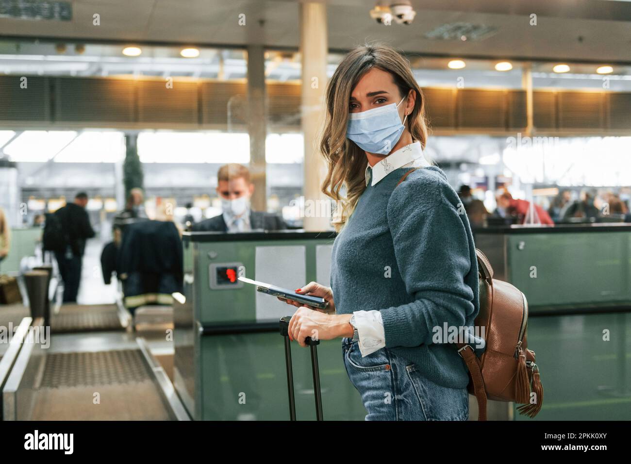Receiving help from worker. Young female tourist is in the airport at ...