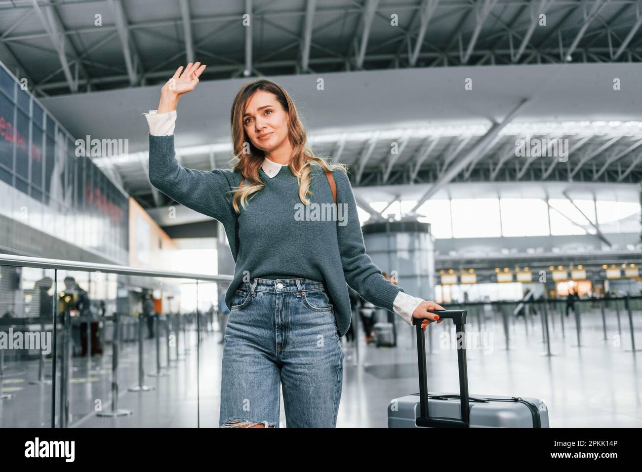 Hello gesture. Young female tourist is in the airport at daytime Stock ...