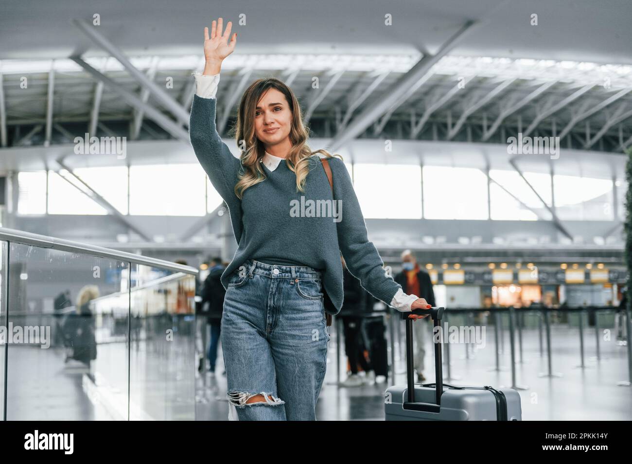 Hello gesture. Young female tourist is in the airport at daytime Stock ...