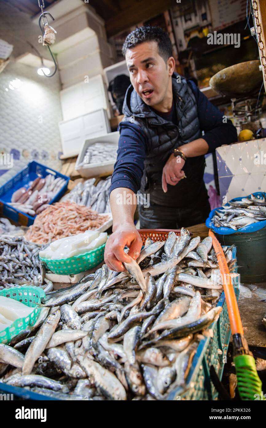 A man reaches for fish on display in a market in Fez Medina Morocco ...