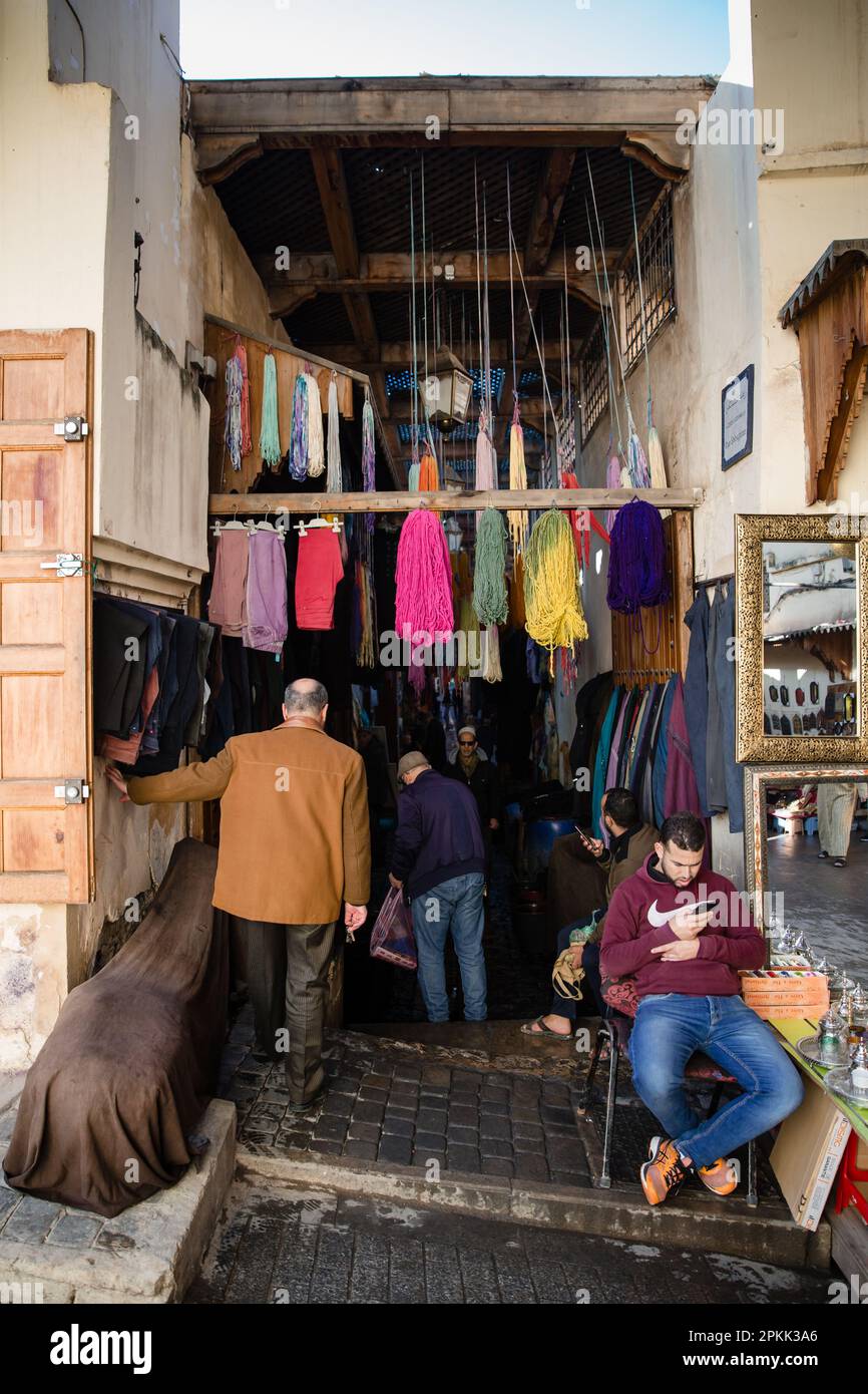 People gather in the entryway to a textile souk in Fez Medina Morocco ...